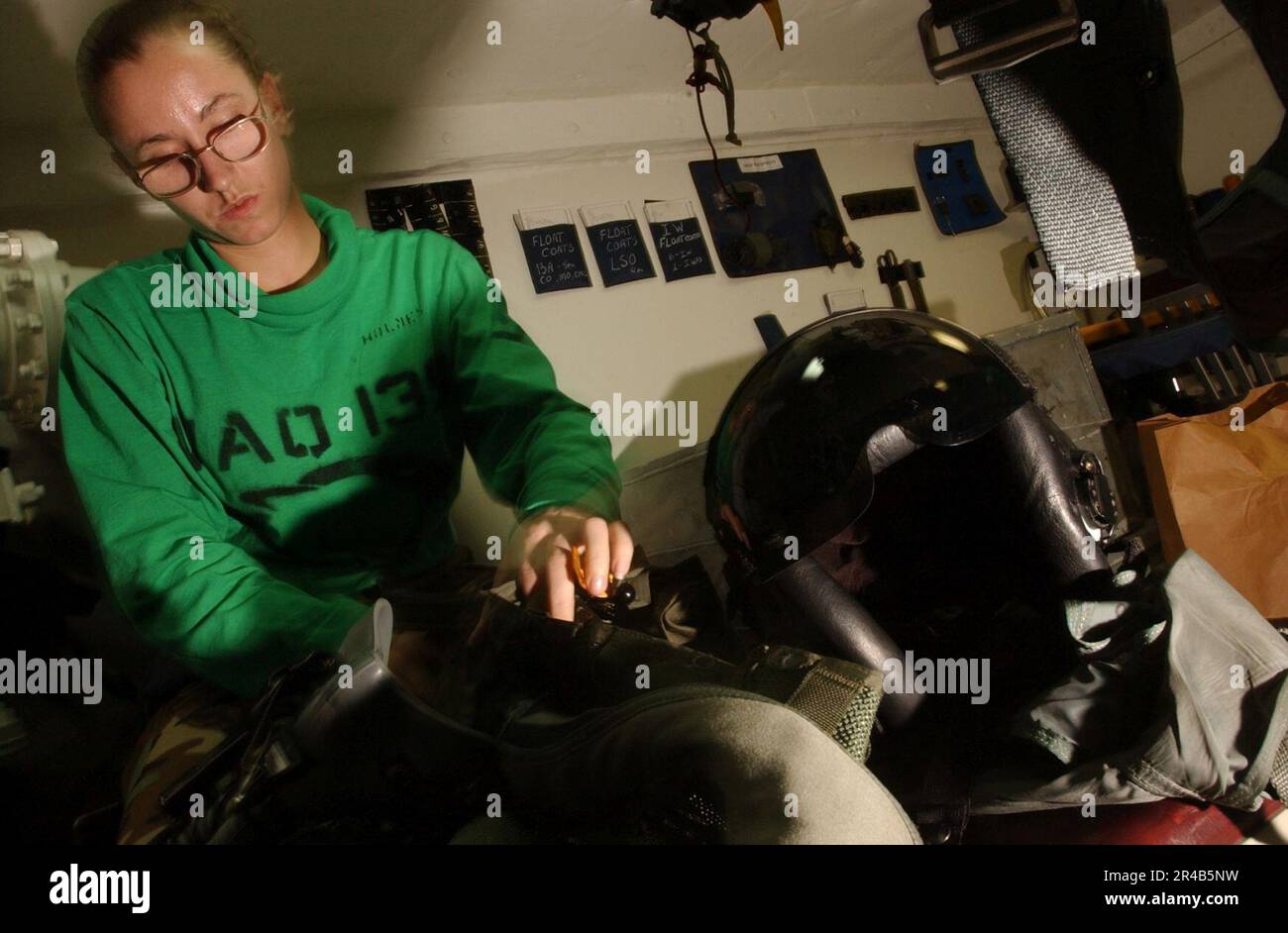 US Navy Aircrew Survival Equipmentman 3rd Class performs maintenance on ...