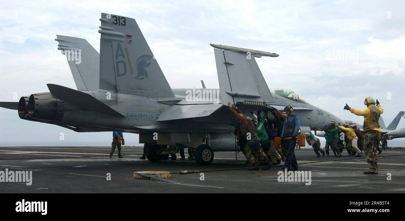 US Navy Flight deck and squadron Sailors help push back an F-A-18C ...
