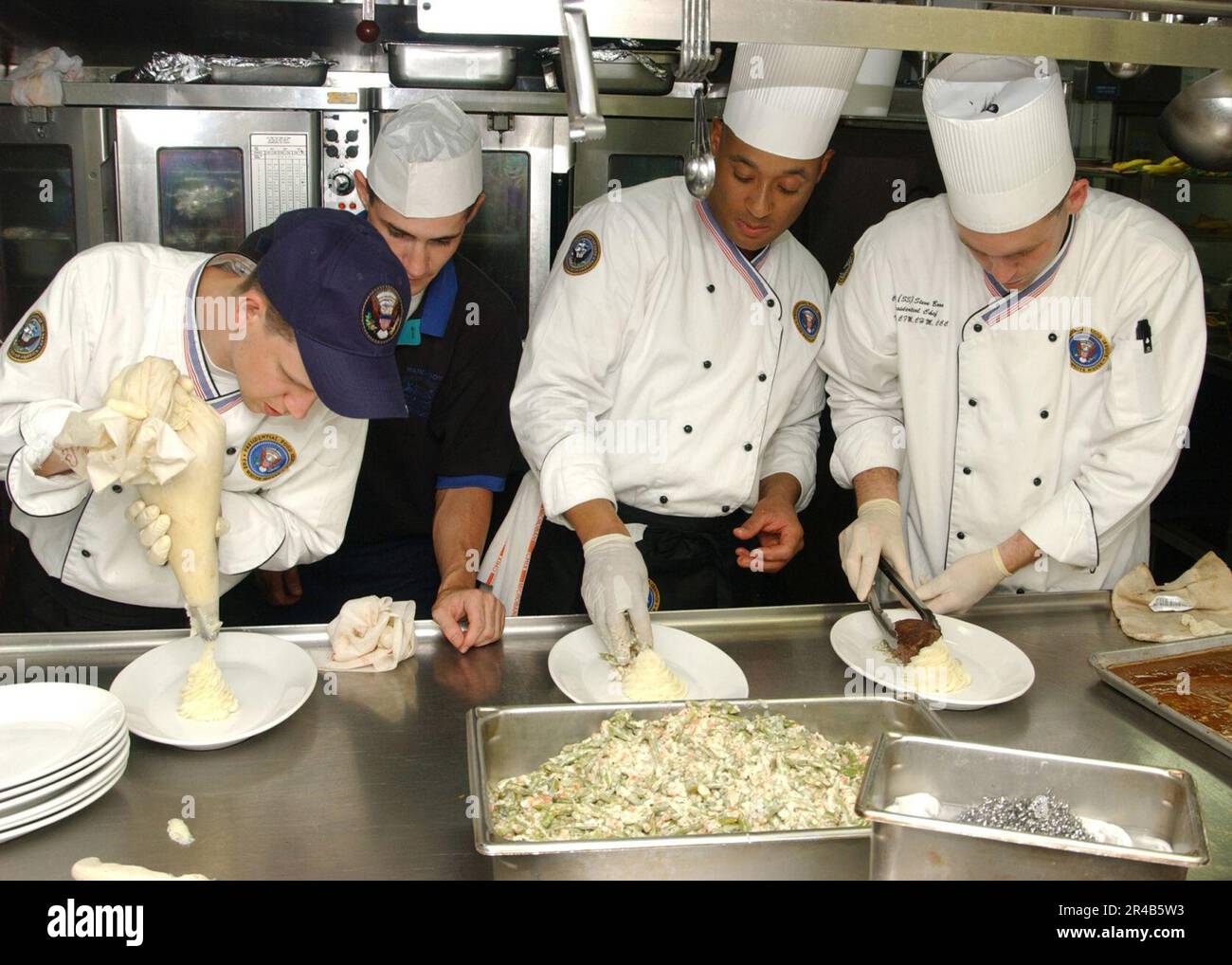 US Navy Culinary Specialists use the assembly line method while making ...