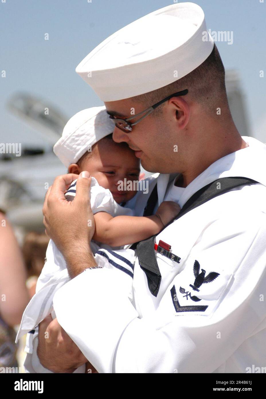 US Navy A Sailor hold his child for the first time after returning from ...