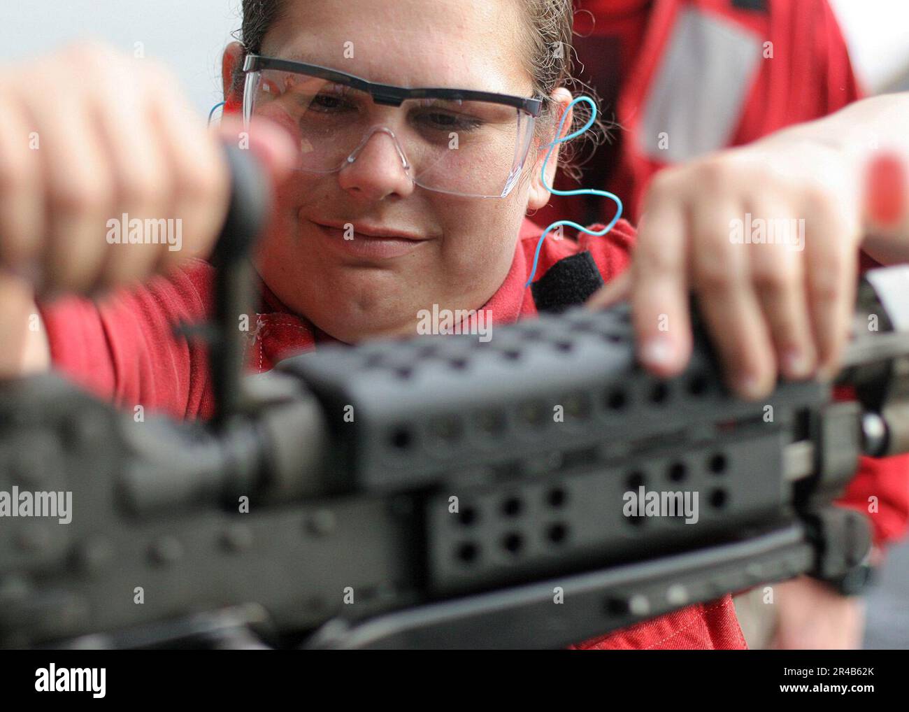 US Navy Gunner's Mate 2nd Class changes out the barrel of an M-240 ...