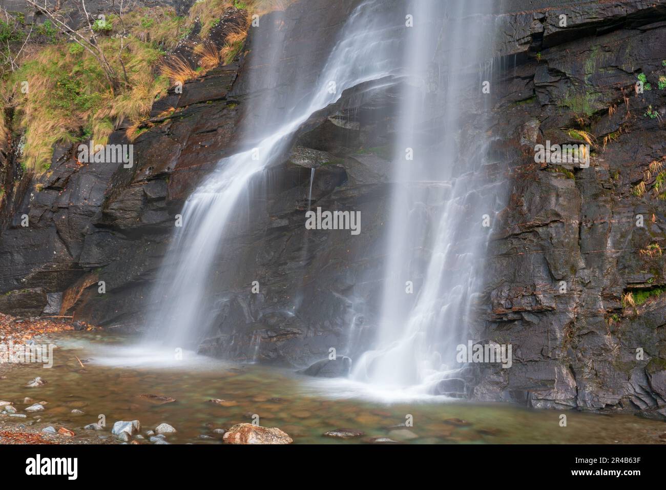 A majestic waterfall cascading down a rugged cliff face surrounded by ...