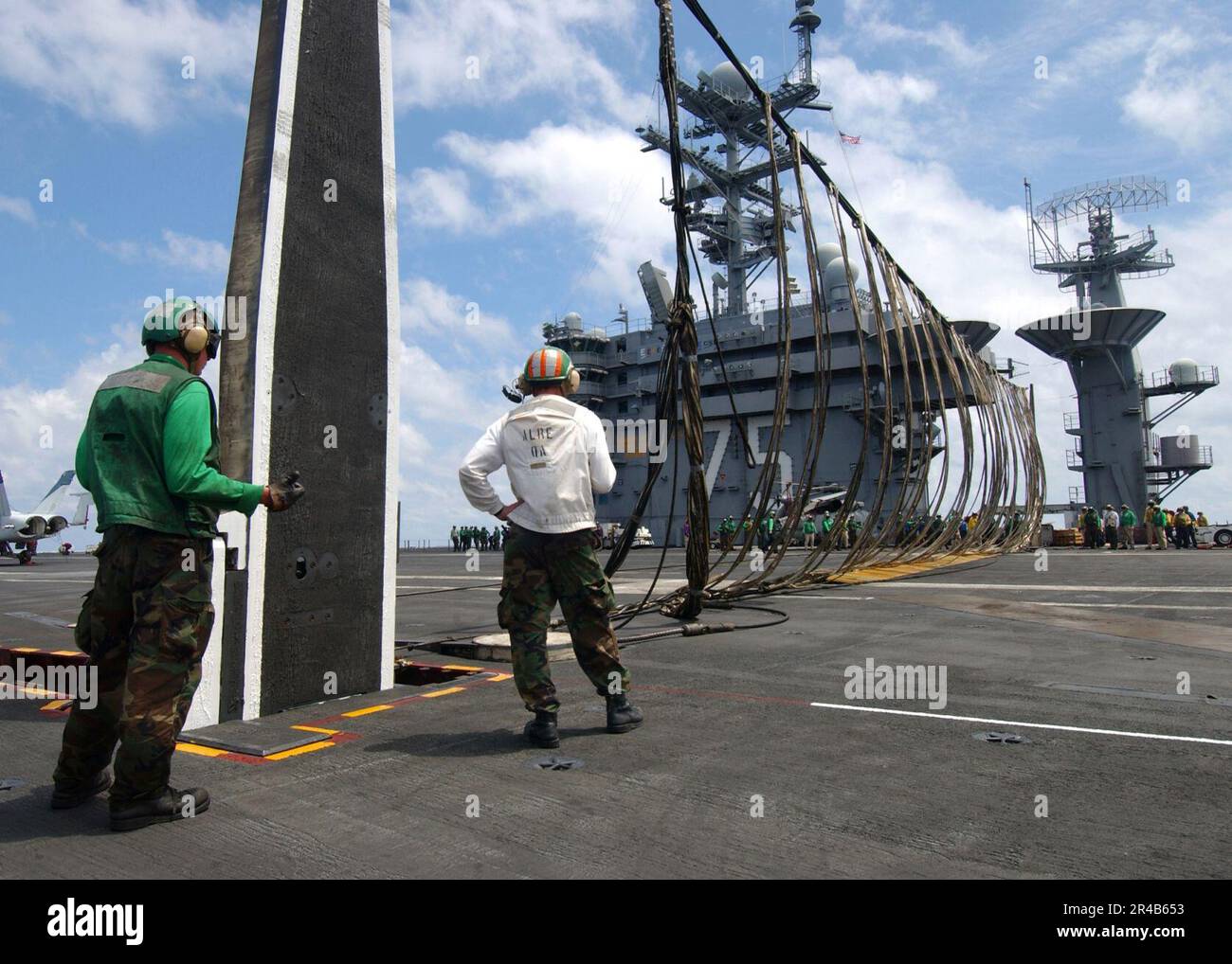 US Navy Air Department Sailors watch as the ship's emergency landing barricade is raised during ...