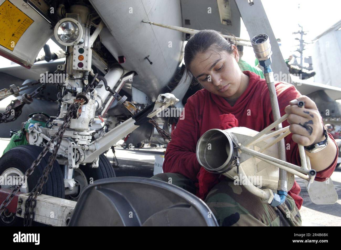 US Navy Aviation Ordnanceman Airman cleans a gun cooling device from an ...