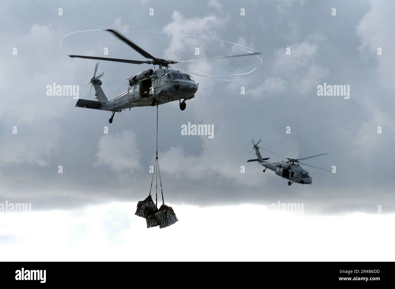 US Navy Two MH-60S Seahawk helicopters, transport cargo pallets during ...
