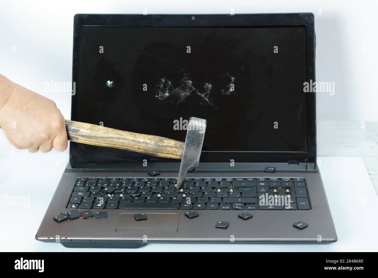 Arm of a man breaking a laptop with a hammer isolated on white ...