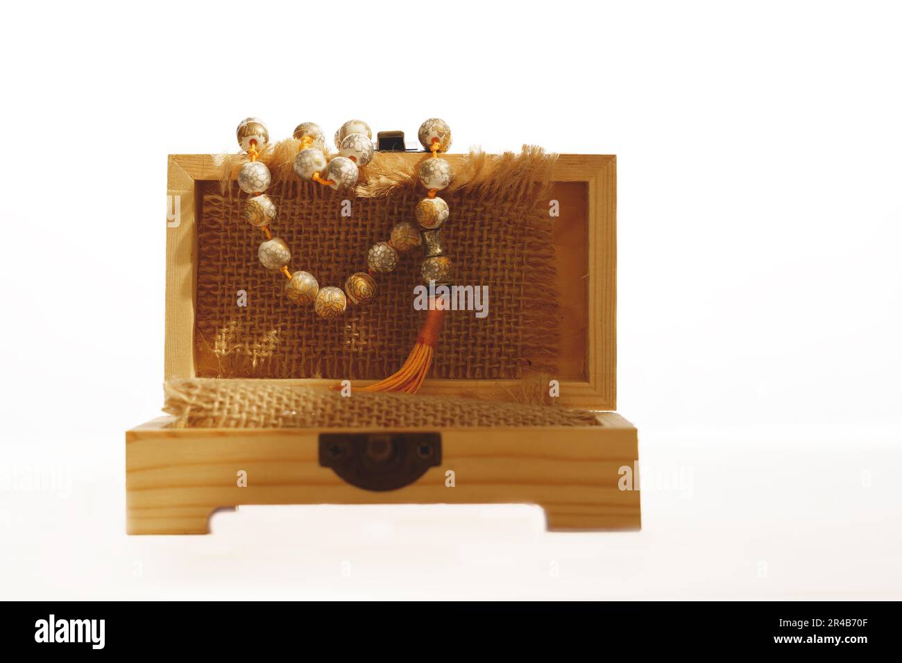 Close-up of a wooden box with a Buddhist japa mala wrapped in a raffia ...