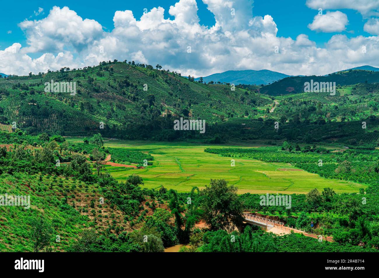 An idyllic river winding through vibrant green hills and trees with ...