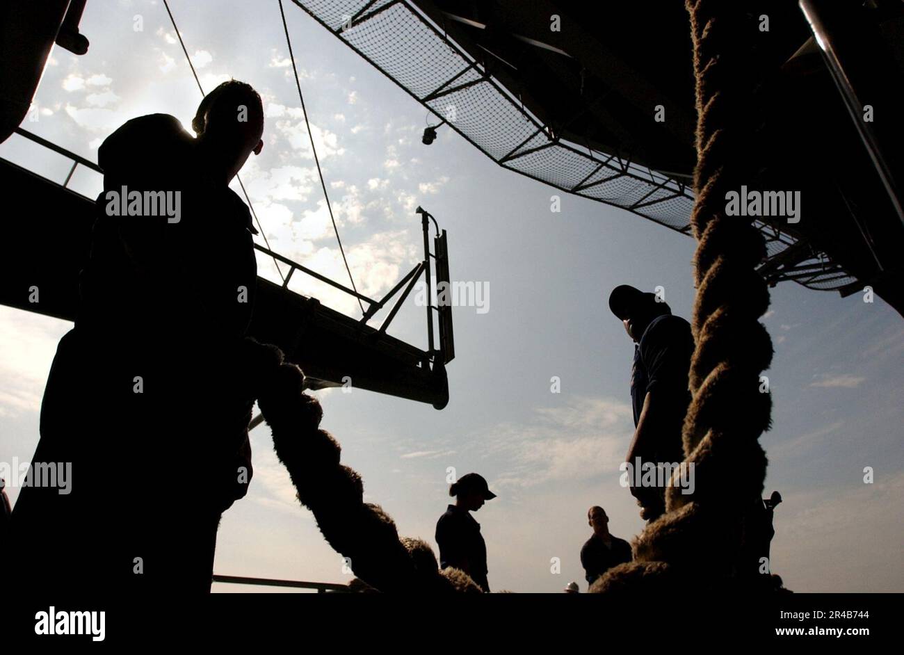 US Navy Sailors assigned to Deck Department guide mooring lines for stowage on the fantail ...