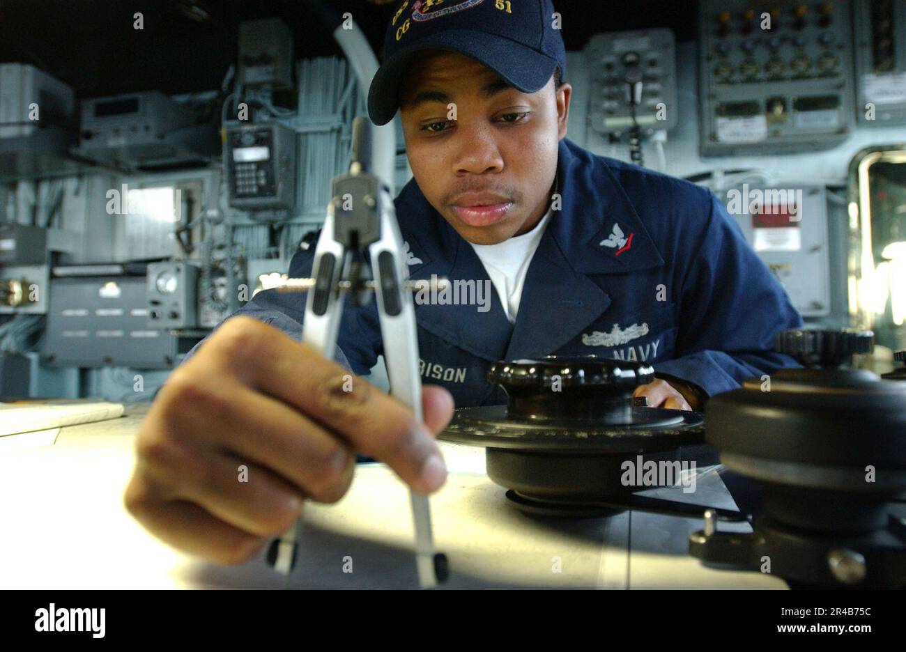 US Navy Quartermaster 3rd Class plots a course in the pilot house of ...