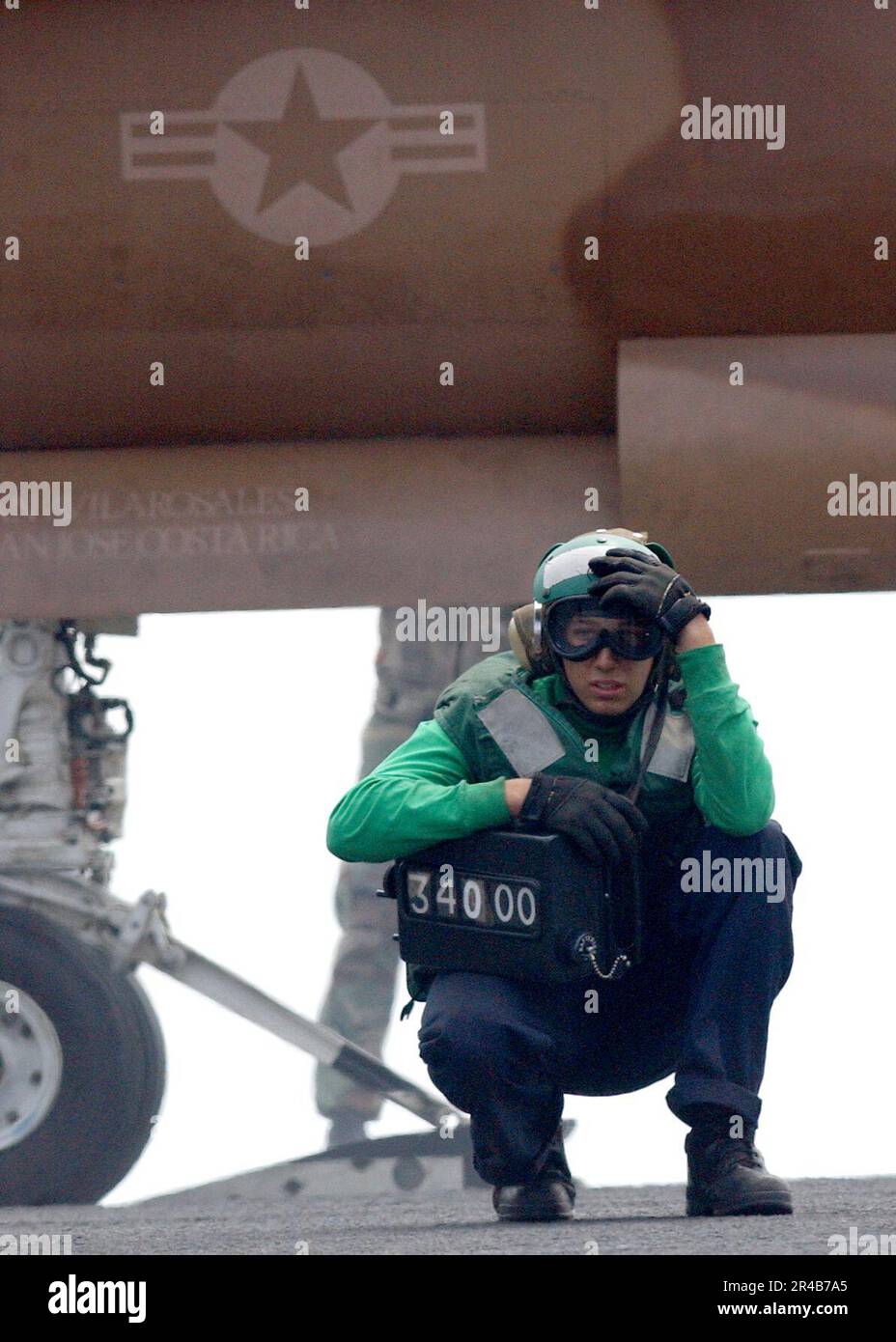 US Navy Airman the catapult one weight board operator, waits for the ...