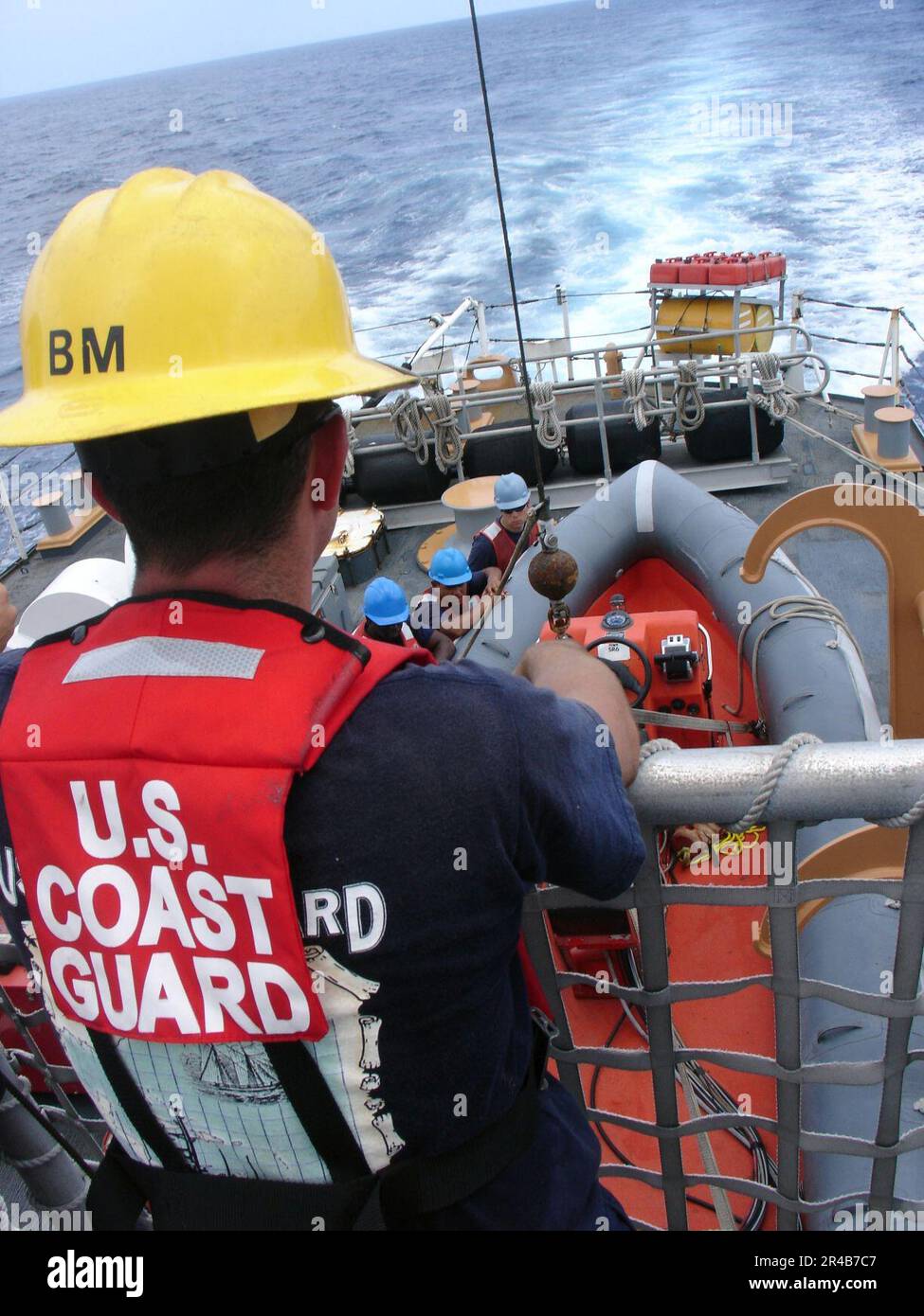 US Navy U.S. Coast Guard Boatswain's Mate 3rd Class serves as a safety ...