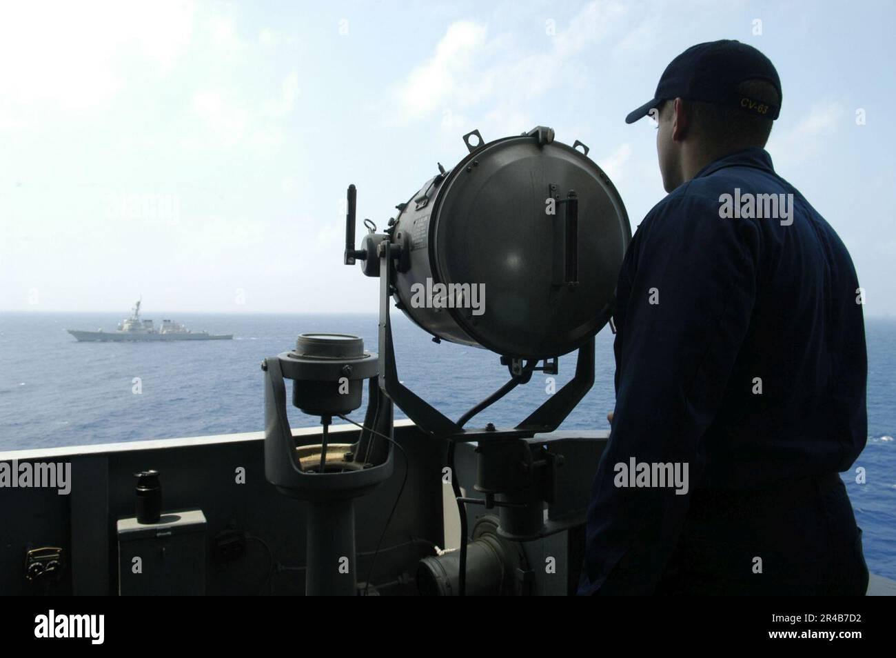 US Navy Quartermaster 2nd Class uses flashing light to communicate with ...