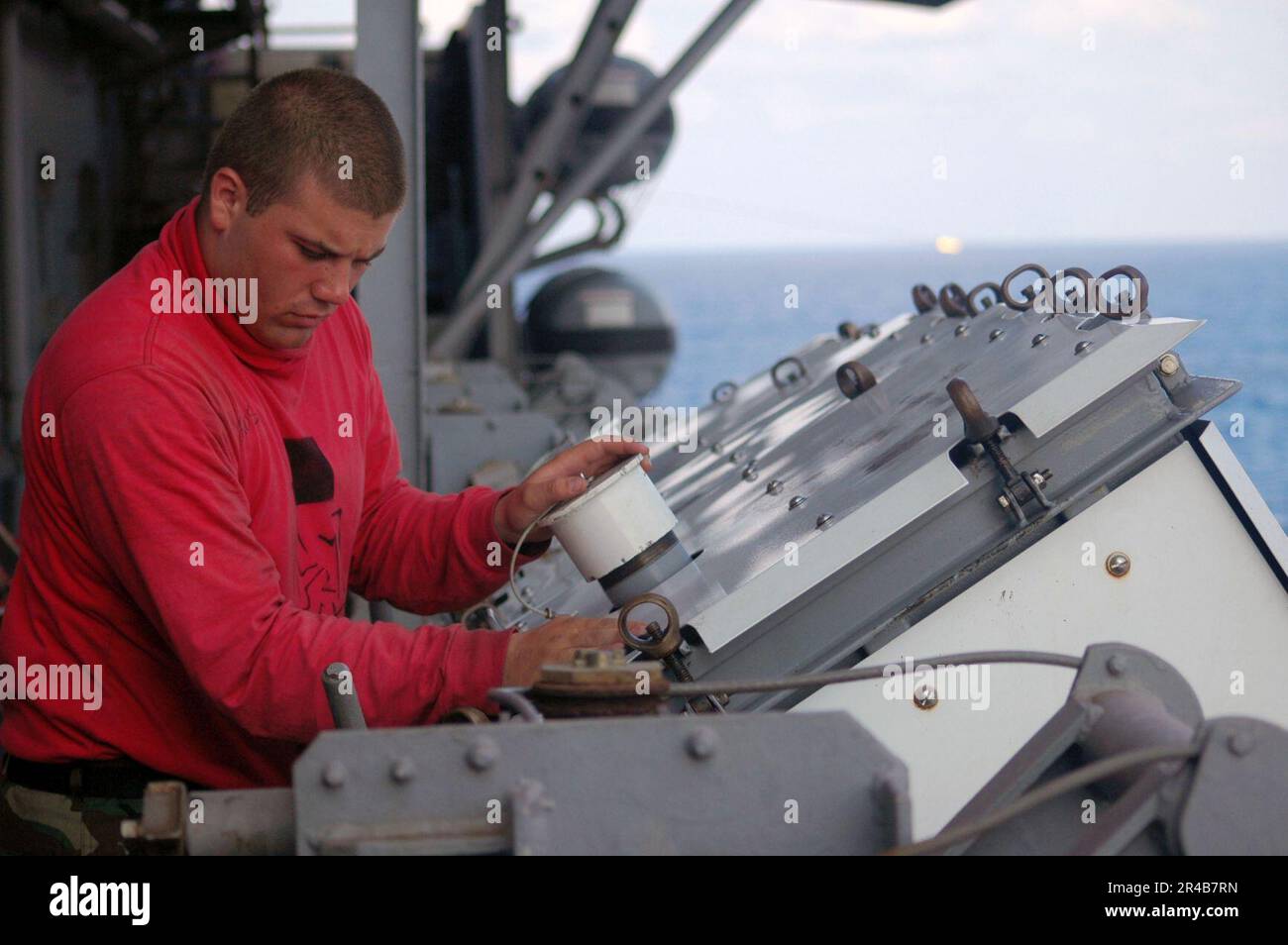 US Navy Aviation Ordnanceman Airman cleans an ammunition jettison ...