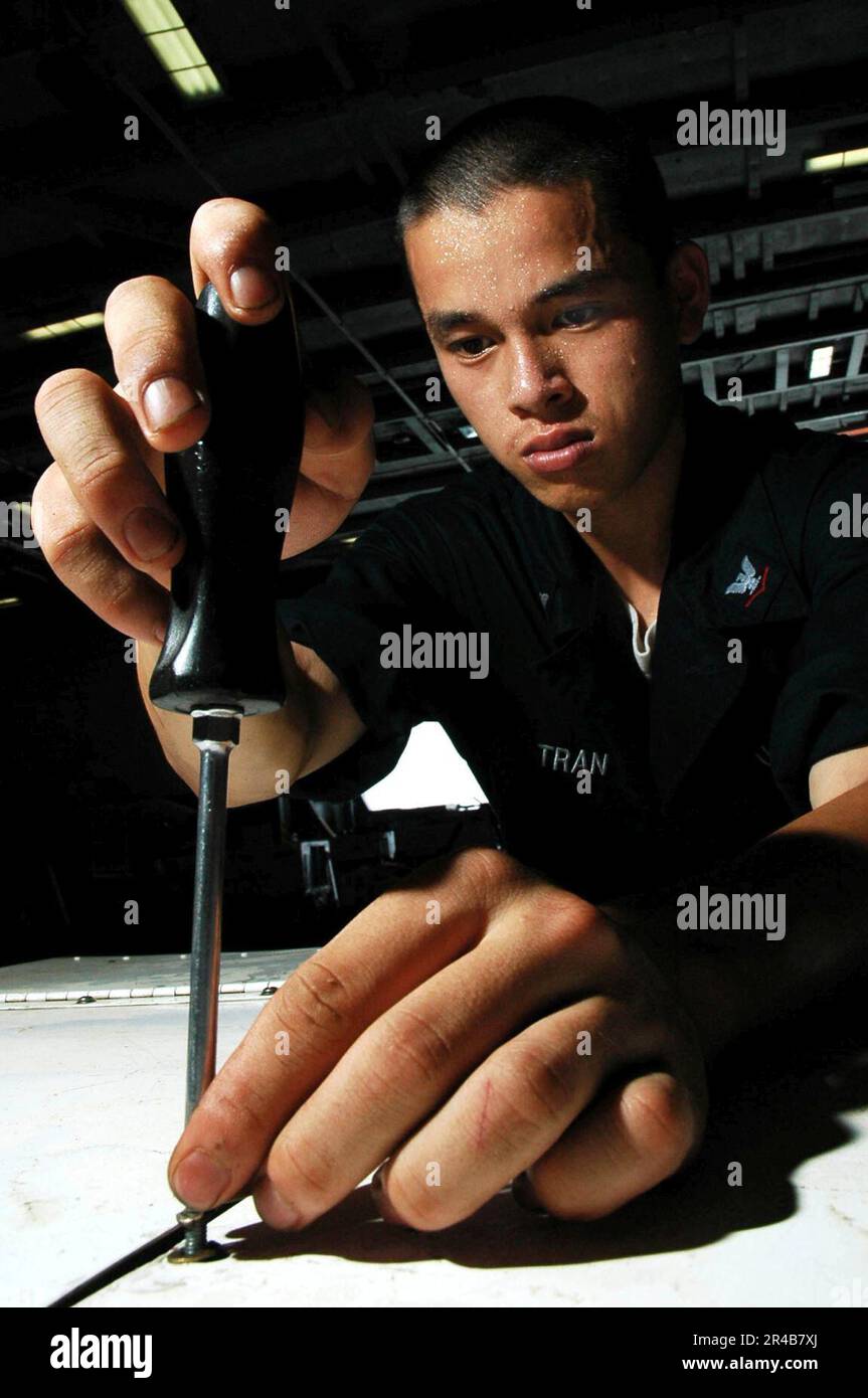 US Navy Aviation Support Equipment Technician 3rd Class screws on a ...