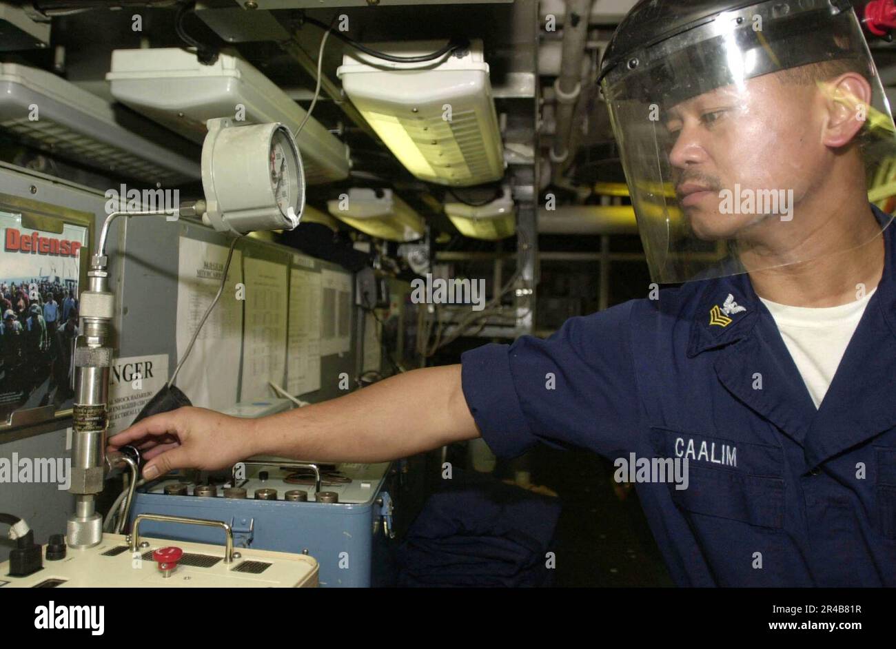 US Navy Machinist's Mate 1st Class calibrates an air pressure gauge in ...