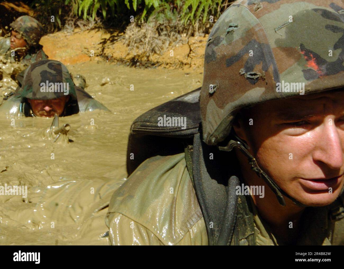 US Navy U.S. Navy Seabees low-crawl through mud-filled trenches during ...