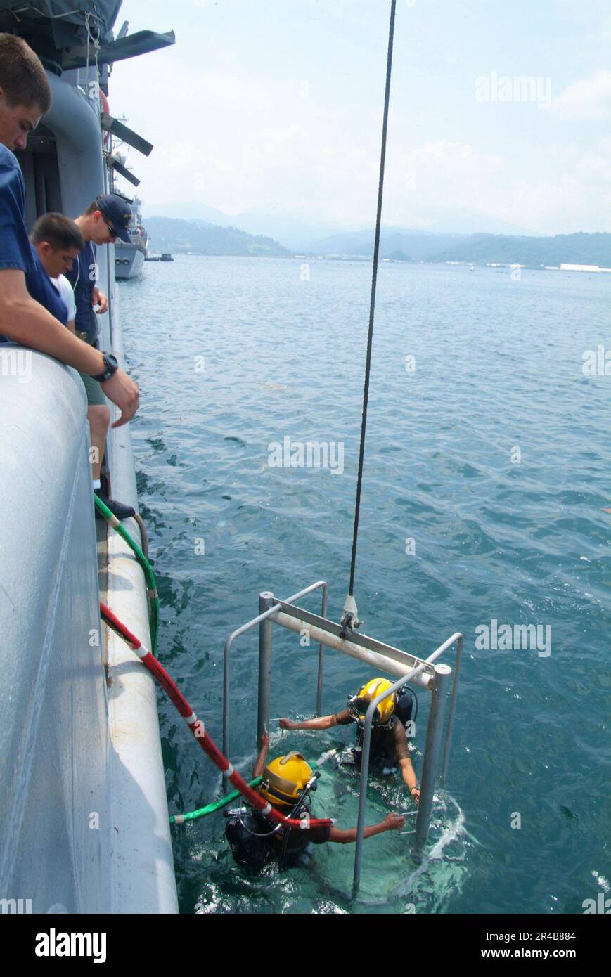 US Navy A pair of Philippine Navy divers are raised from the water ...