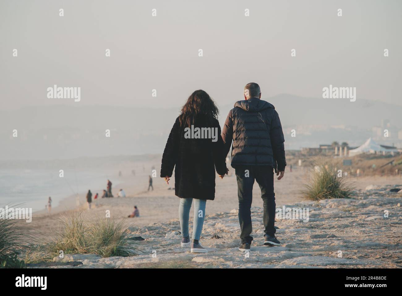 Two people are standing on the beach, facing the ocean Stock Photo - Alamy