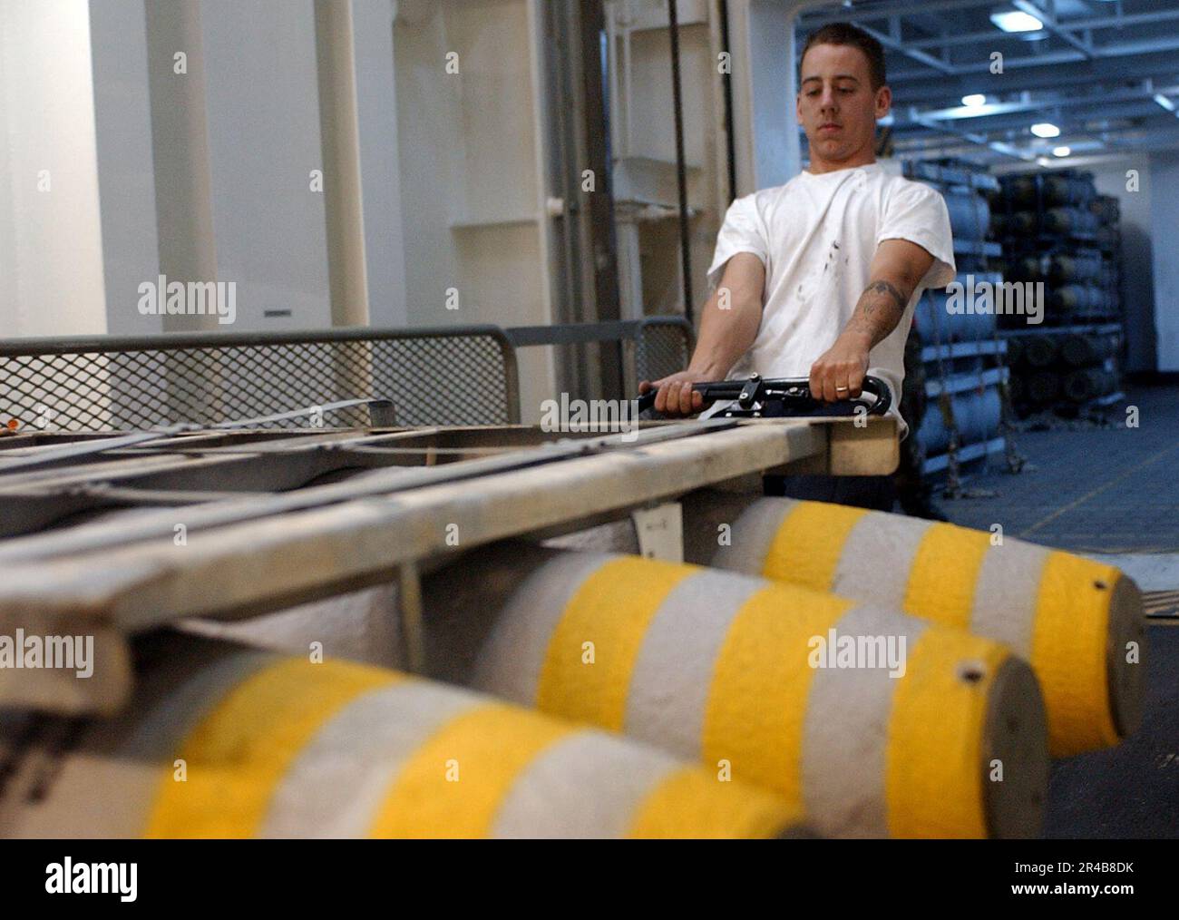 US Navy Aviation Ordnanceman Airman moves general-purpose bombs into a ...