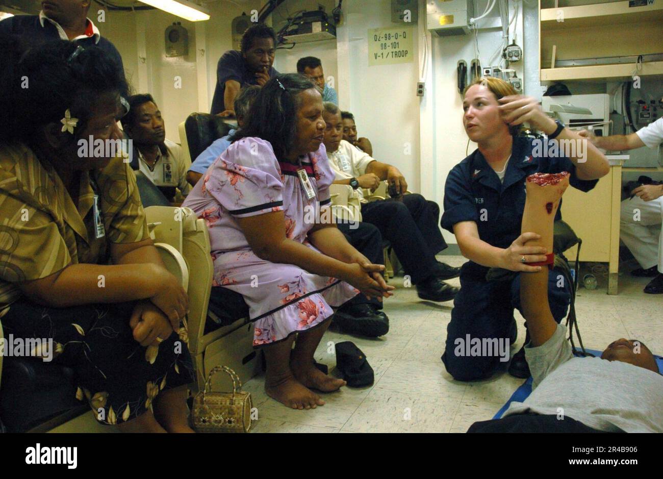 US Navy Disbursing Clerk 2nd Class demonstrates first aid to citizens ...