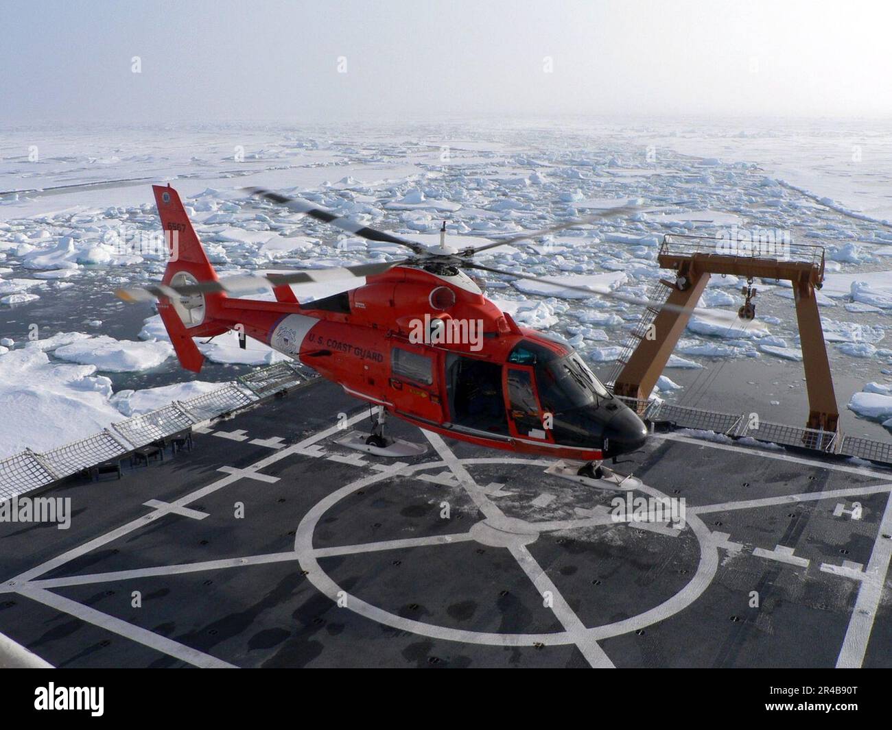 US Navy A U.S. Coast Guard HH-65 Dolphin helicopter prepares to depart ...