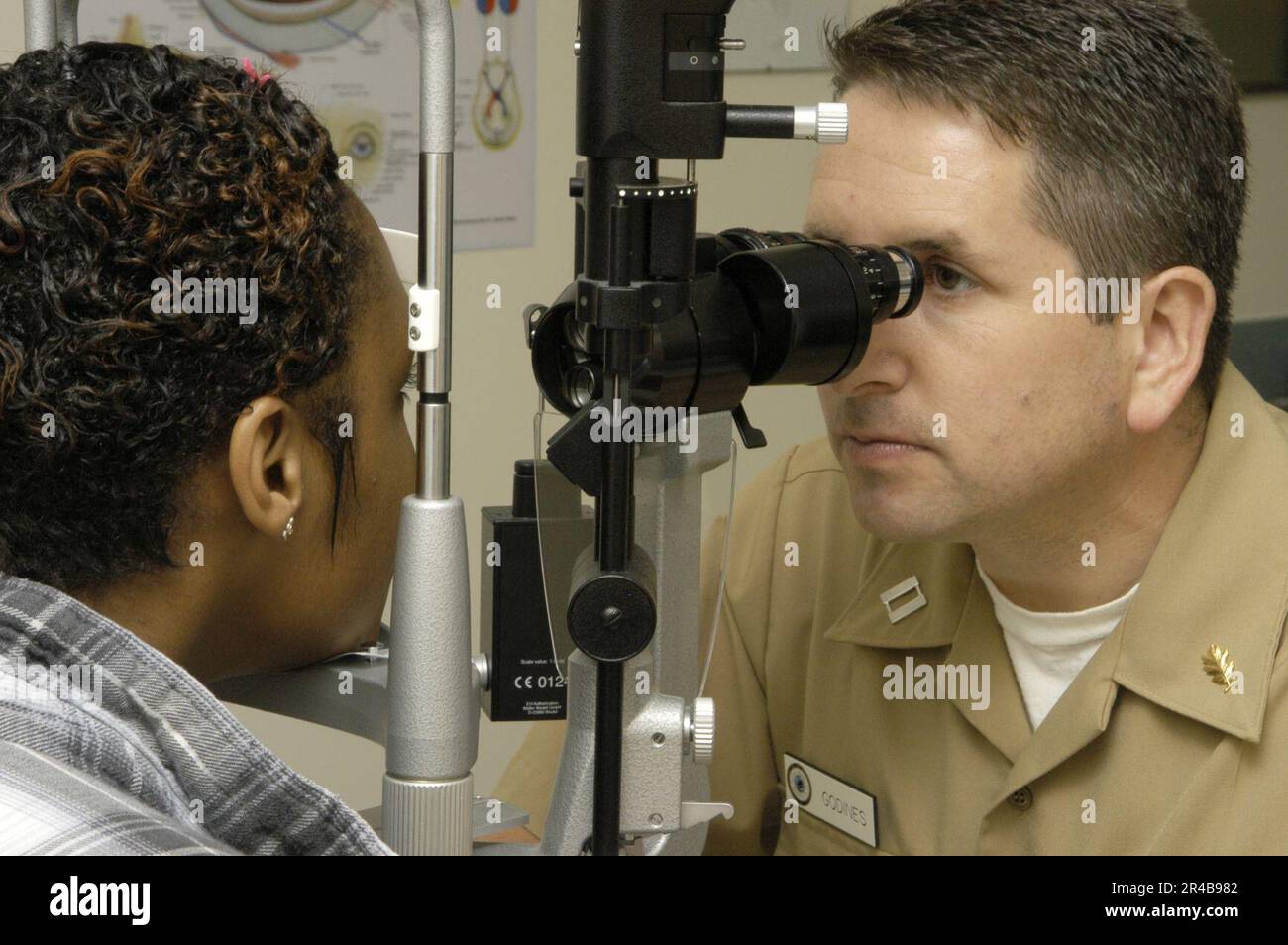US Navy Lt. uses a Bio Microscope to check a patient's eye at the ...