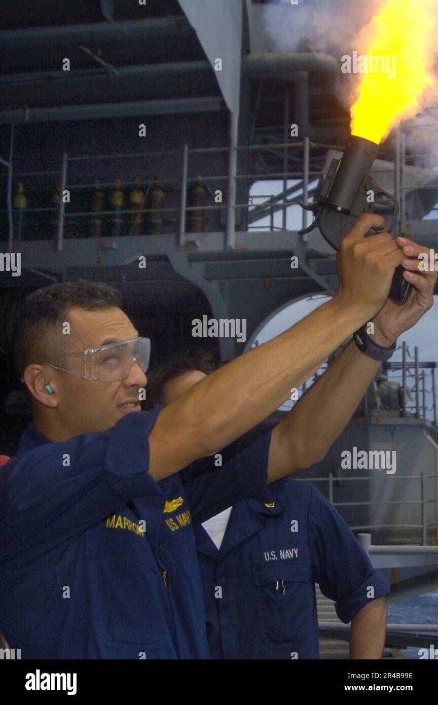 US Navy Lt. j.g. fires a flare gun off the fantail aboard the ...