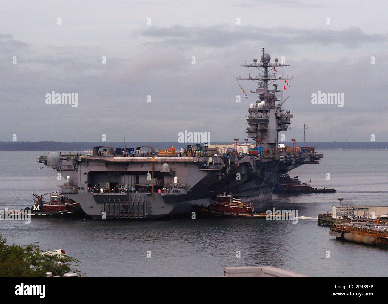 US Navy Tug boats assist the Nimitz Class aircraft carrier USS George ...
