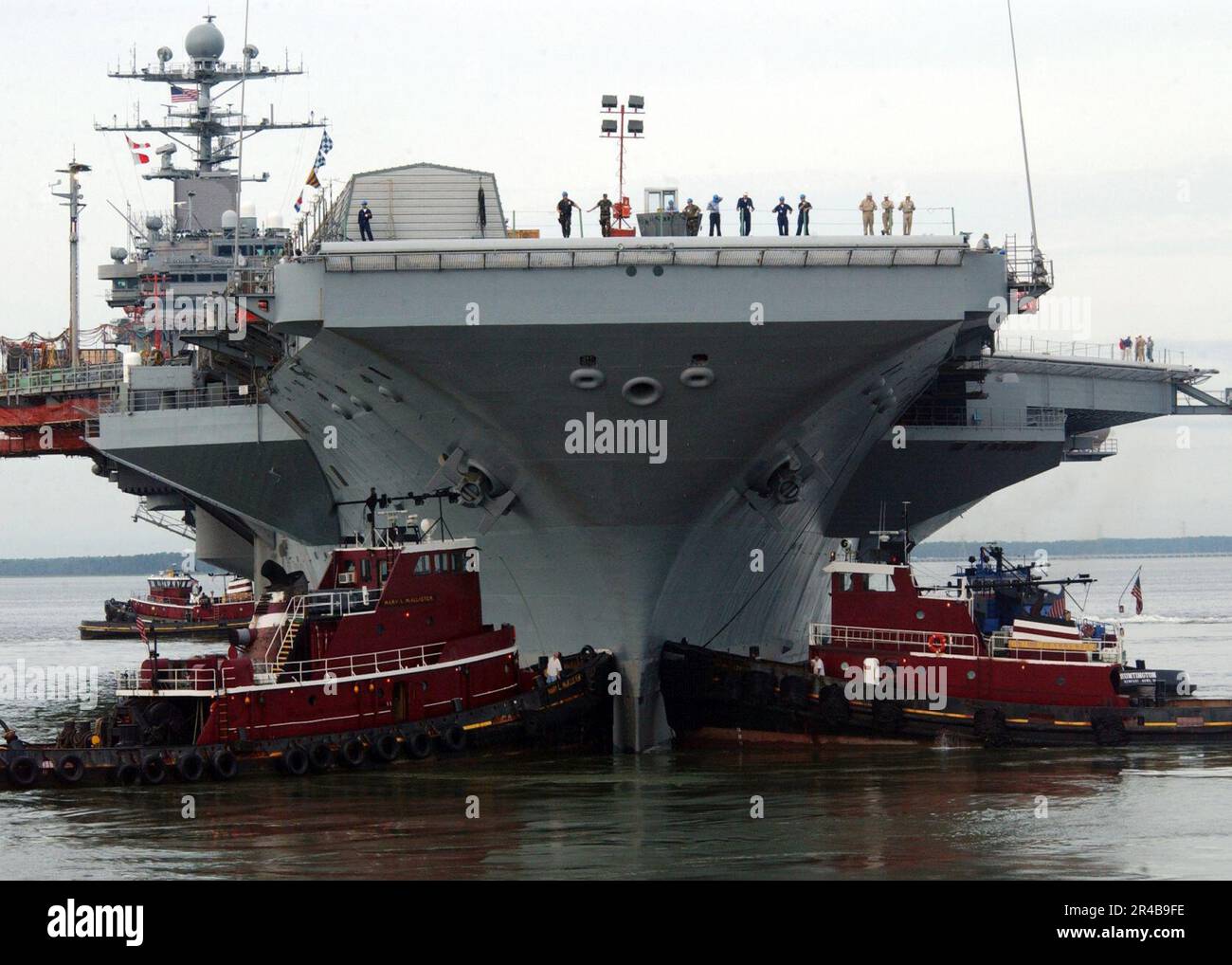 US Navy Two tug boats steady the bow of the Nimitz Class aircraft ...