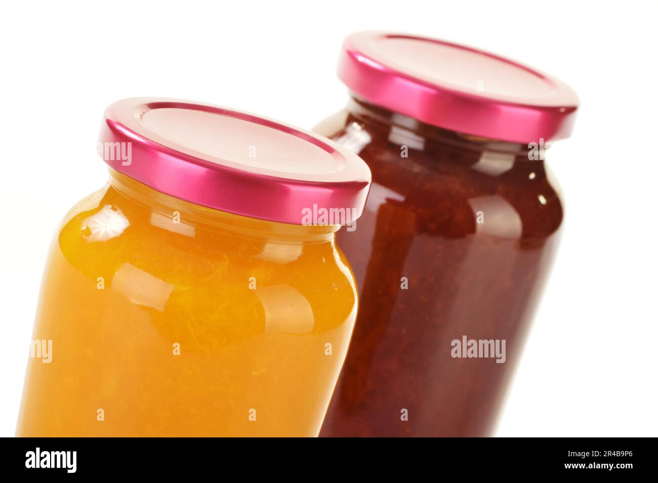 Two jars of fruity jams isolated on white background. Preserved fruits ...