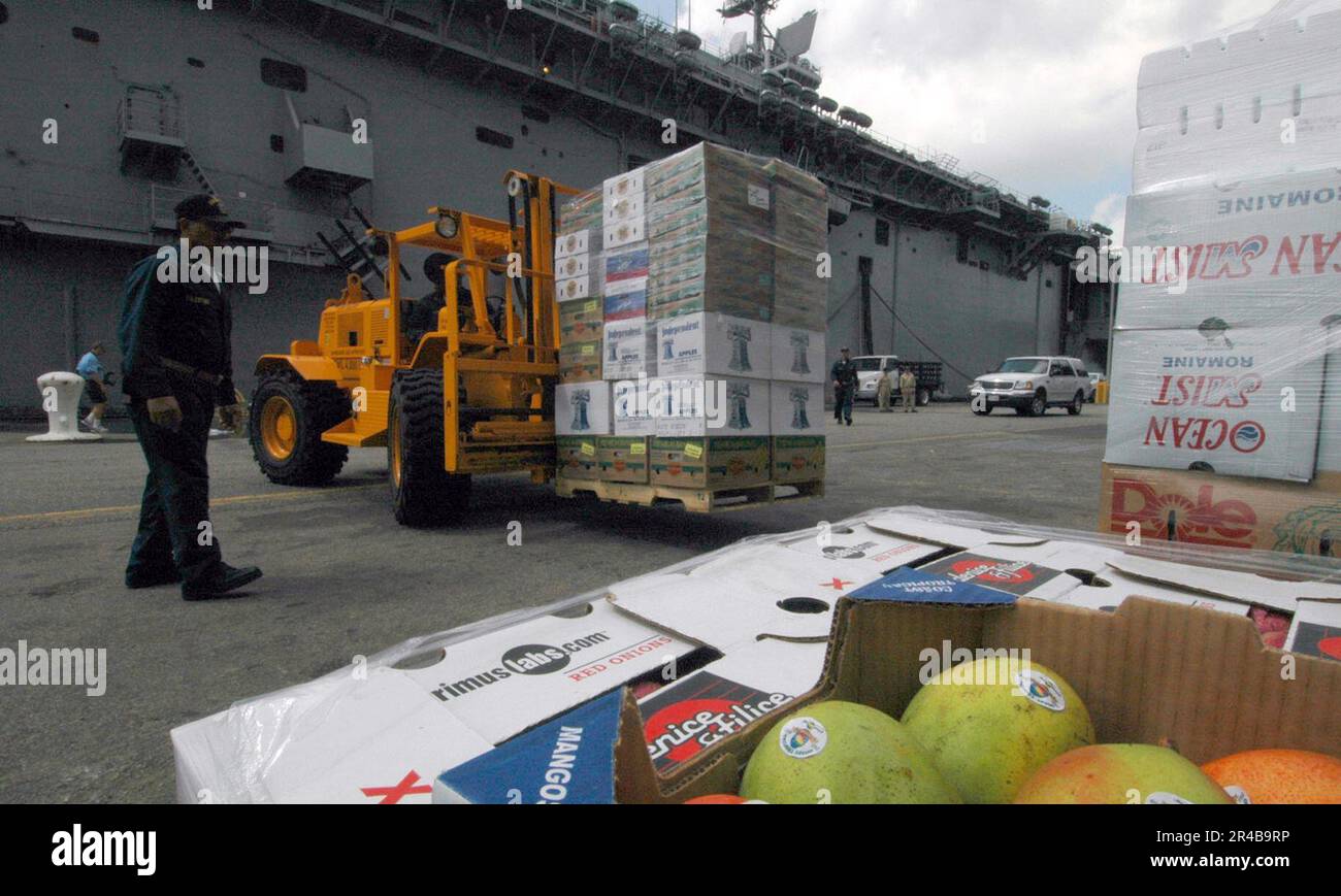 US Navy Master Chief Culinary Specialist directs a forklift during a ...