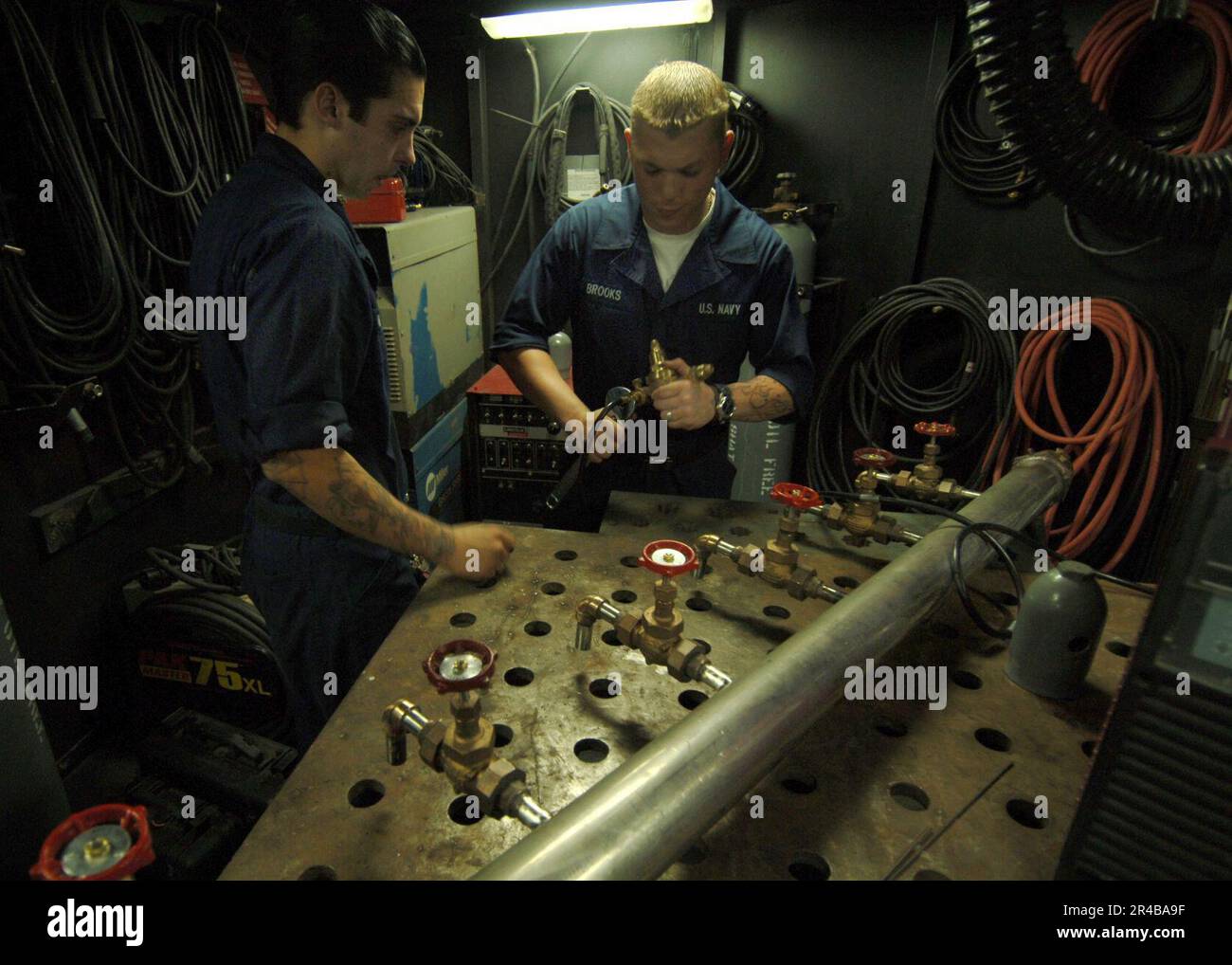 US Navy Hull Technician Fireman left, and Hull Technician Fireman weld ...