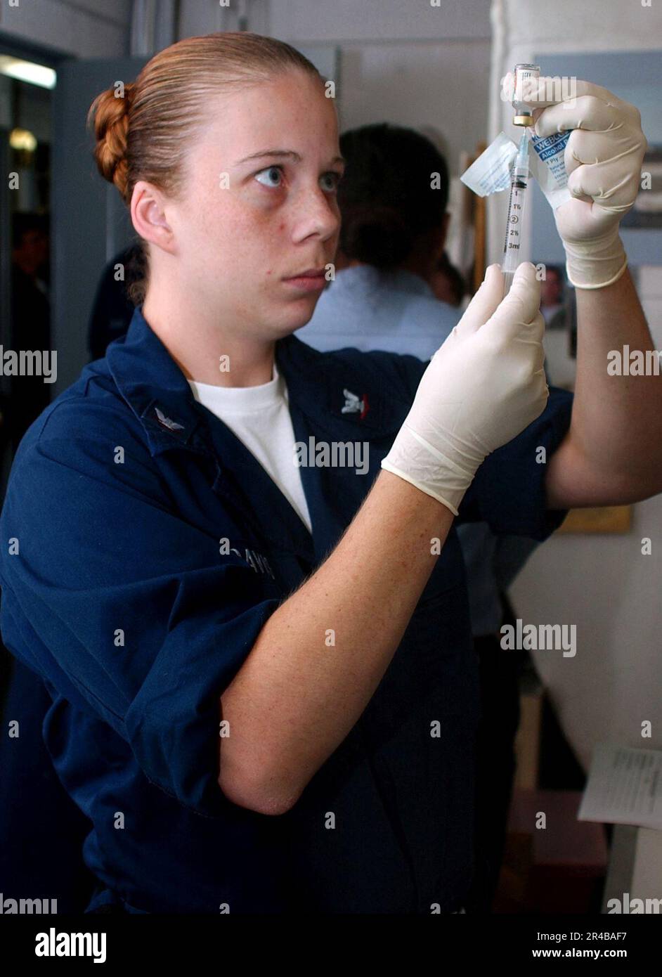 US Navy Hospital Corpsman 3rd Class prepares a syringe for the ...