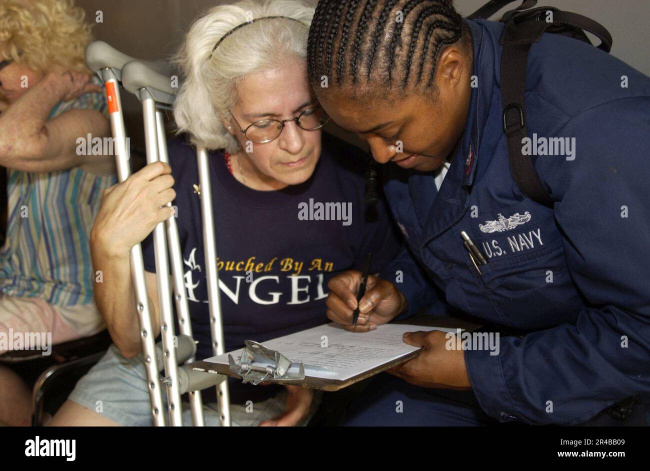 US Navy A U.S. Navy Sailor helps a Hurricane Katrina victim fill out ...