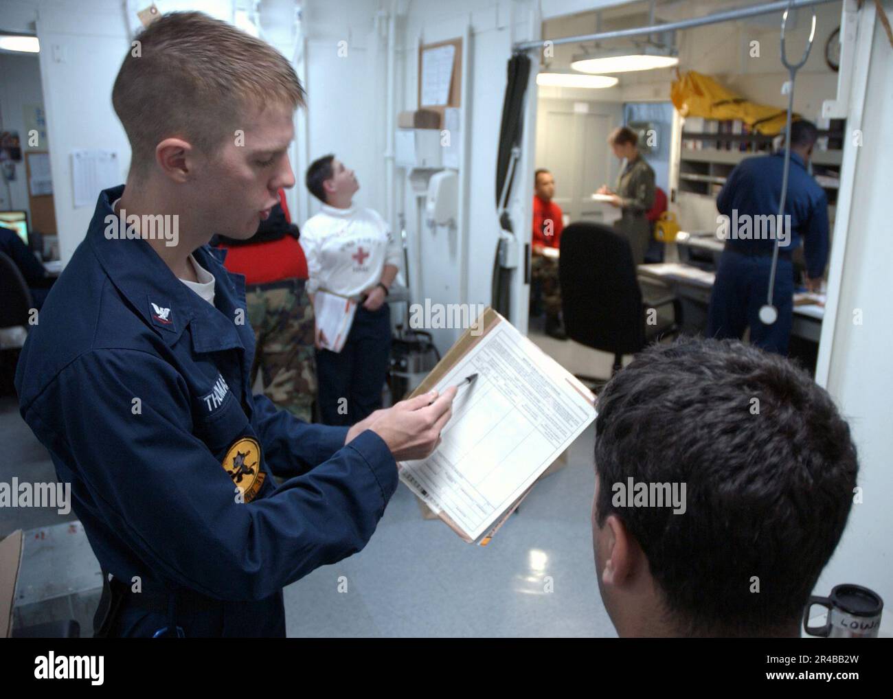 US Navy Hospital Corpsman 3rd Class reviews a patients medical record ...