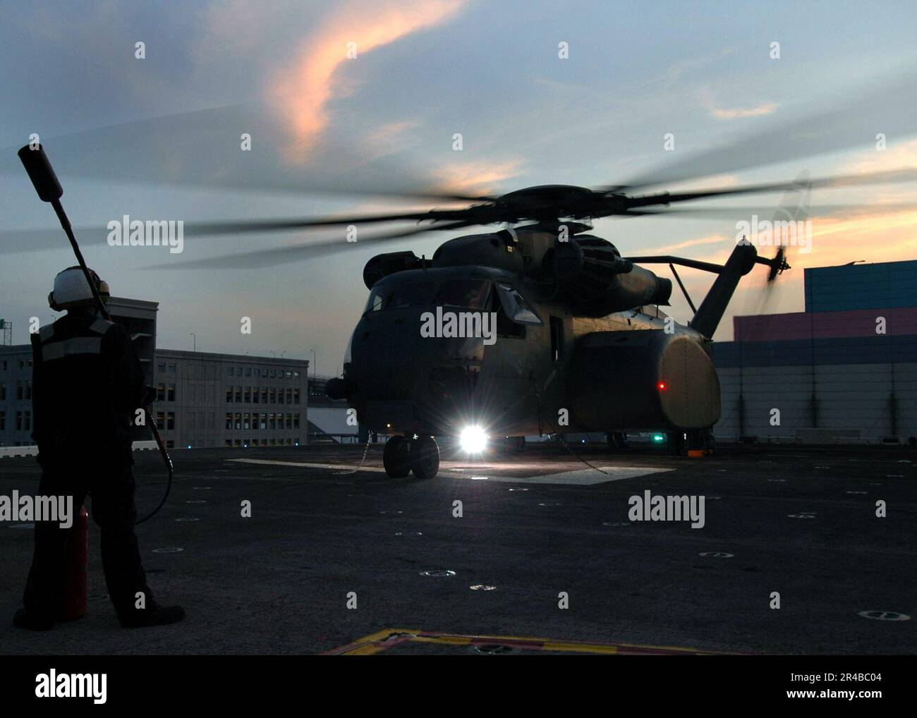 US Navy A flight deck Sailor stands with CO2 bottle ready to assist in case of any mishap as a ...