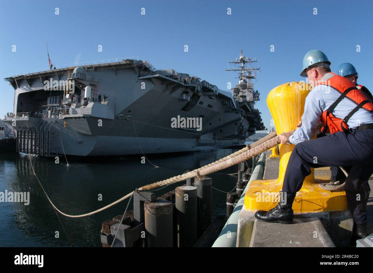 US Navy Hull Technician 1st Class casts off a line from the pier as the ...