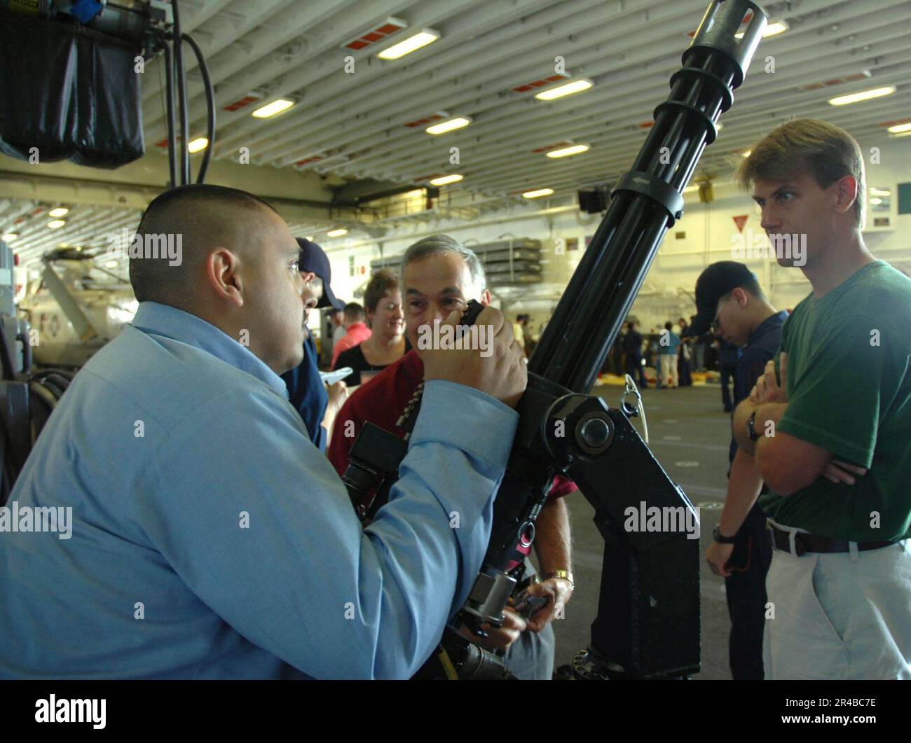 US Navy Gunner's Mate 1st Class demonstrates the operation of a GAU-17 ...