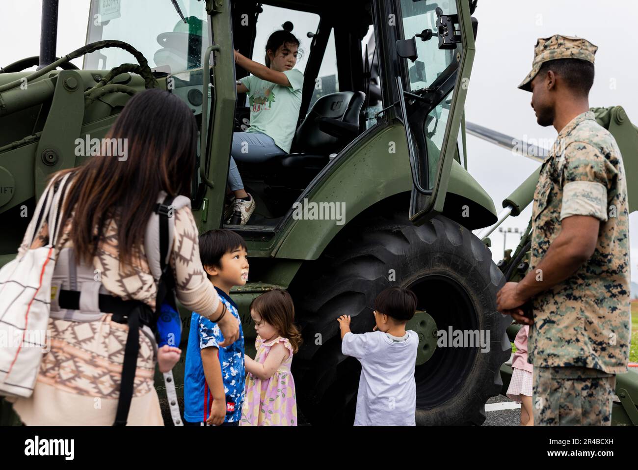 Festival attendees sit in and observe a Medium Crawler Tractor on ...