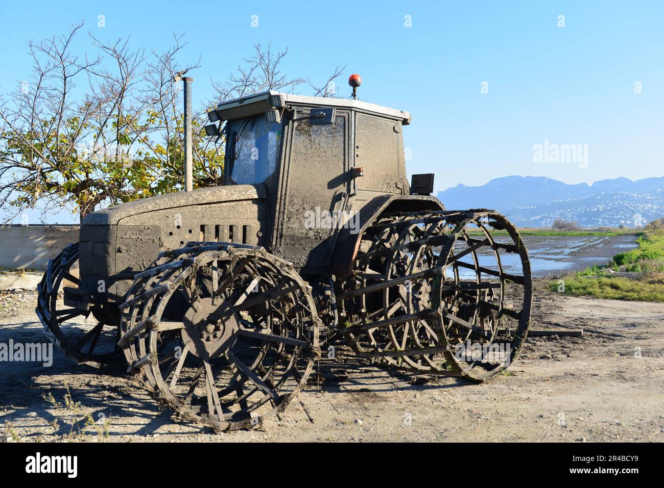 An aged tractor sits abandoned on the roadside, its rusting exterior ...