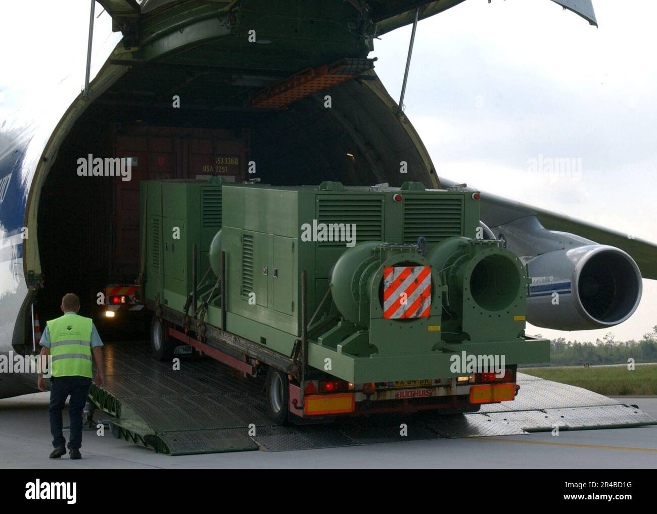 US Navy Military personnel unload a diesel powered water pump flown in ...