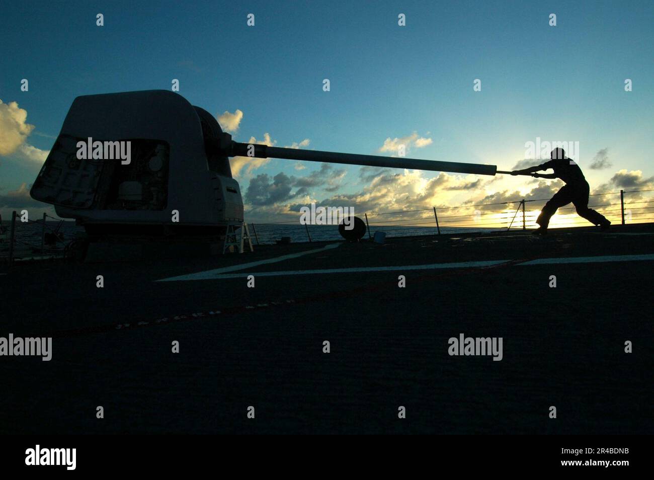 US Navy Gunner's Mate 3rd Class cleans the barrel of a MK-45 5-inch-54 ...