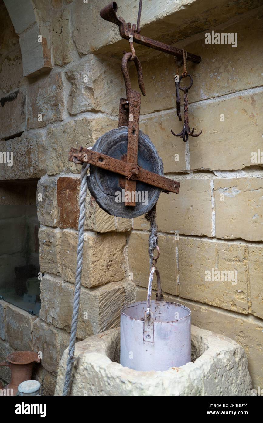 A vintage stone trough is illuminated in a dimly lit setting, showing ...