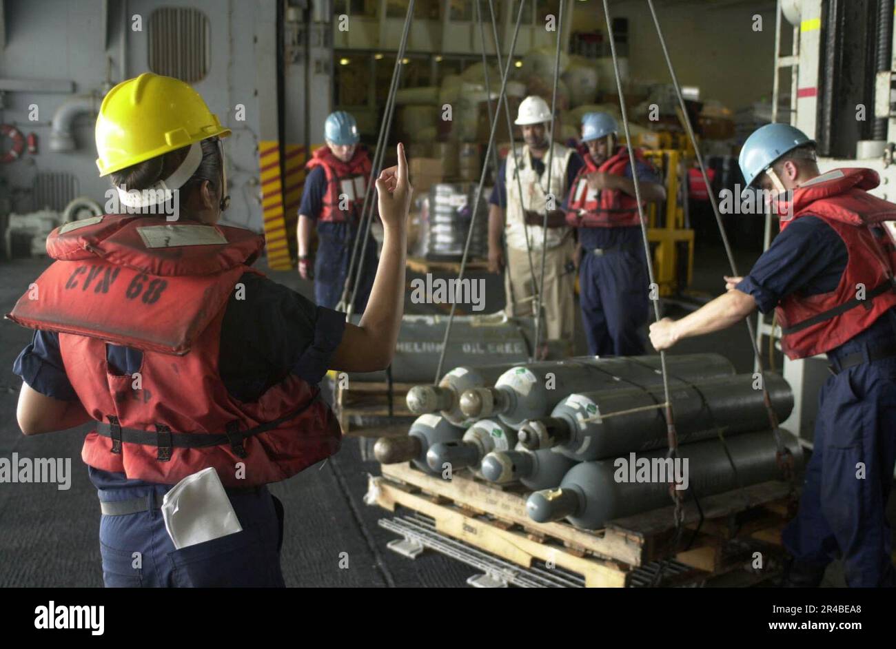 US Navy Boatswain's Mate 3rd Class left, directs off-loading of cargo ...