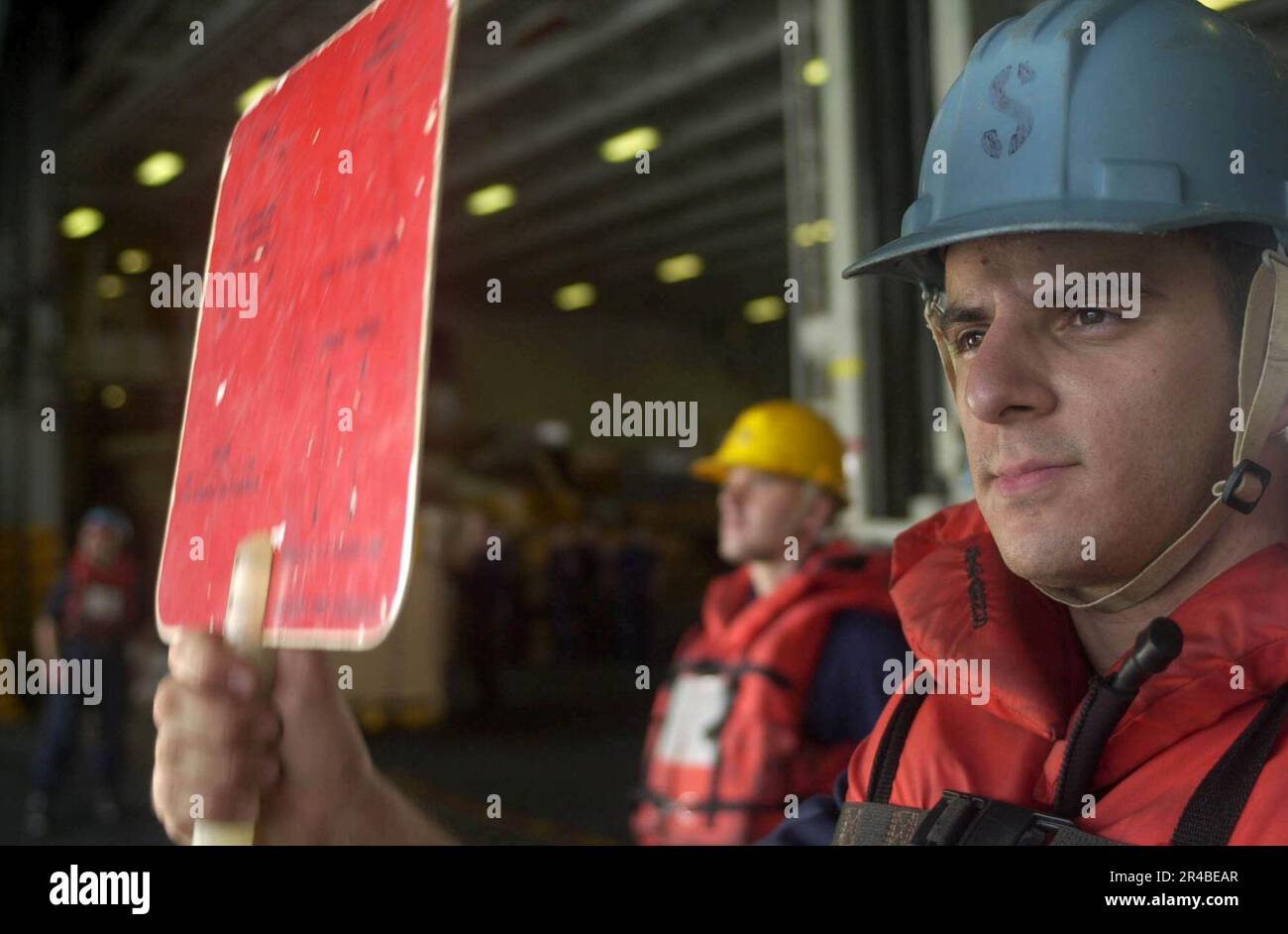 US Navy Seaman flashes the hold signal board during a replenishment at ...