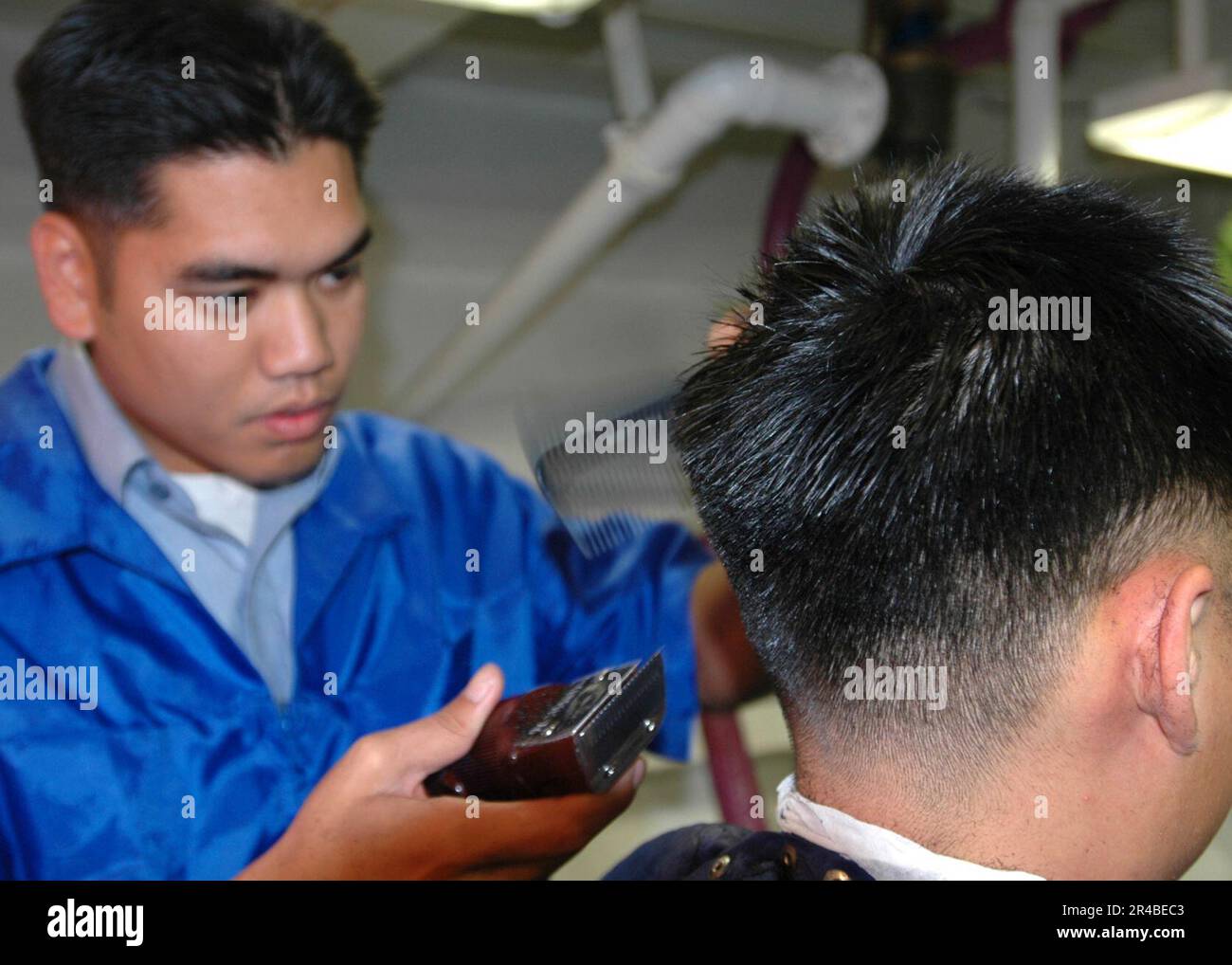 US Navy Ship's Serviceman Seaman trims a Sailor's hair Stock Photo - Alamy