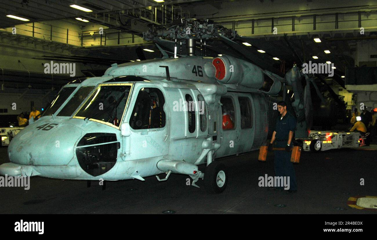US Navy Airman helps guide one of the embarked MH-60S Seahawk ...