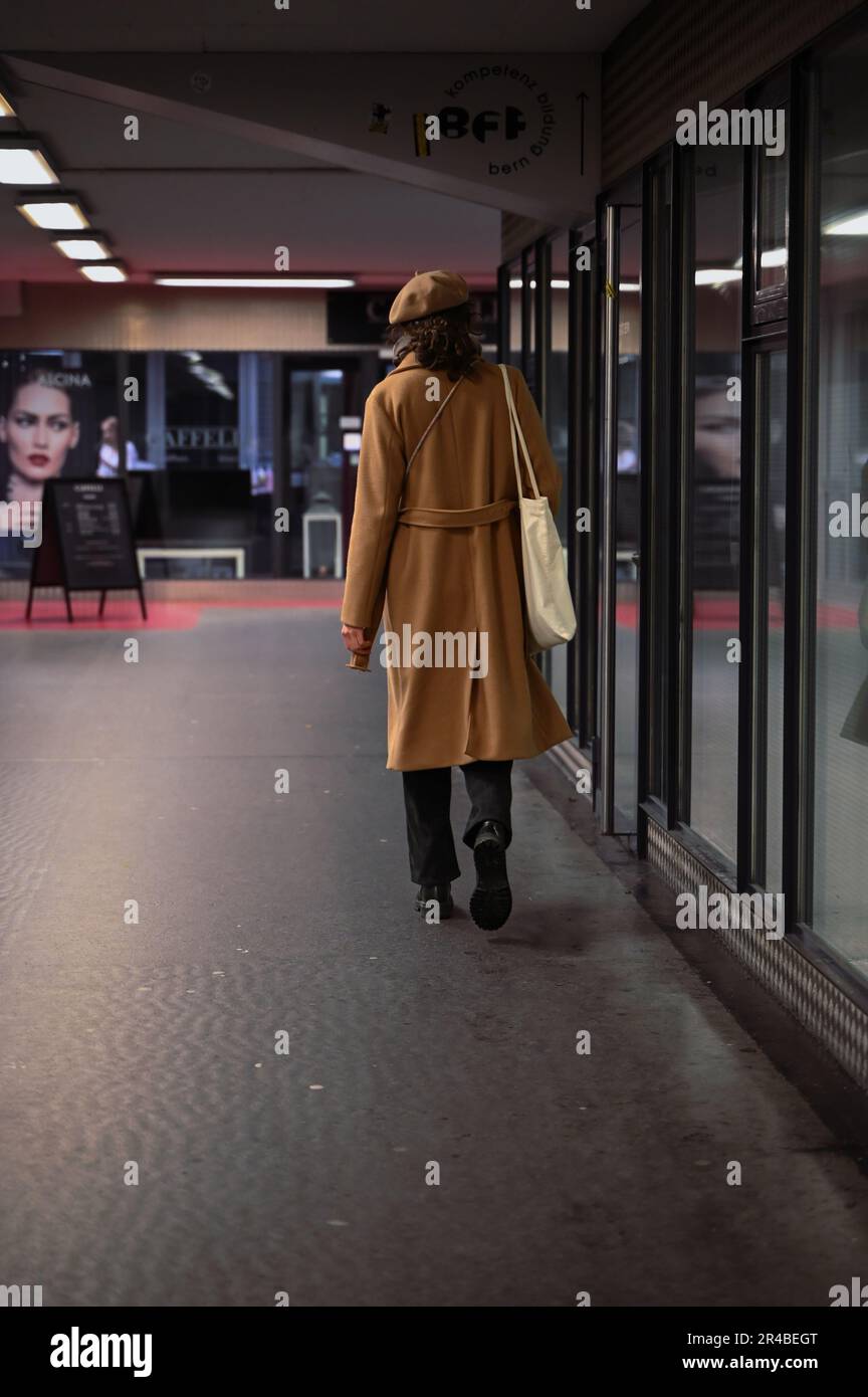 A lone figure in a brown coat strides past a window, with a determined ...