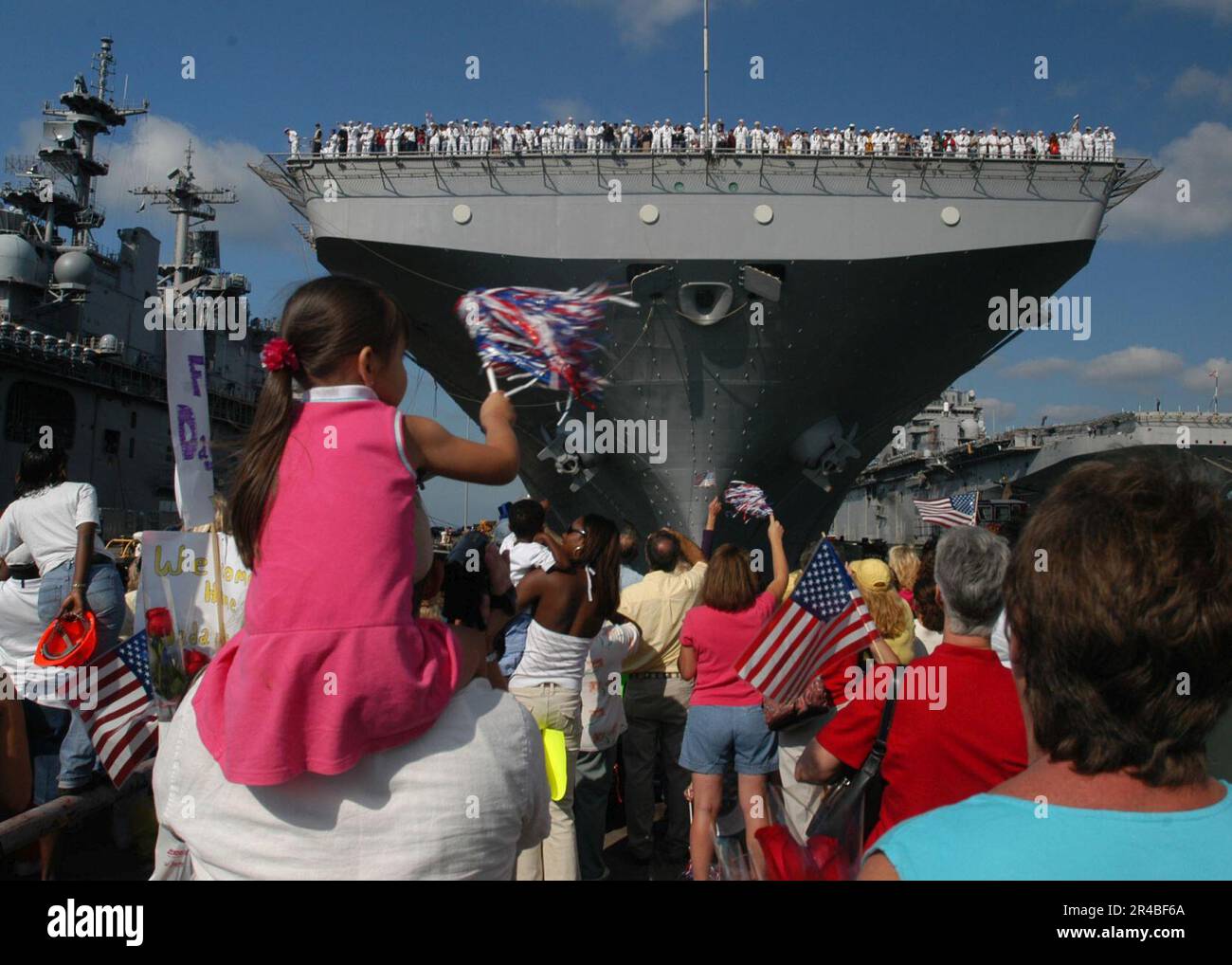 US Navy Friends and family members wave as the amphibious assault ship ...